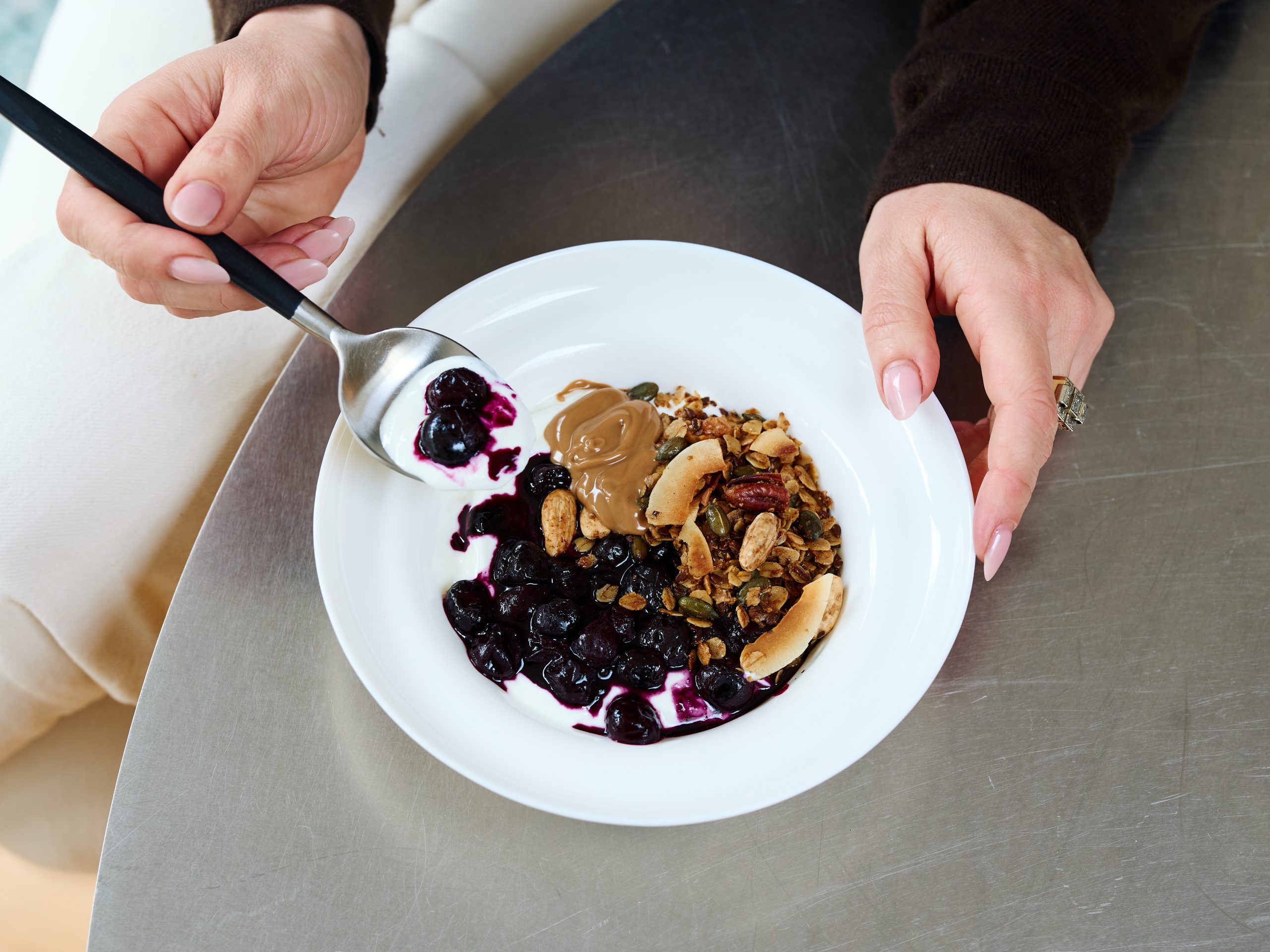Proteïne-yoghurtkom met kruidige granola en gestoofde blauwe bessen ...